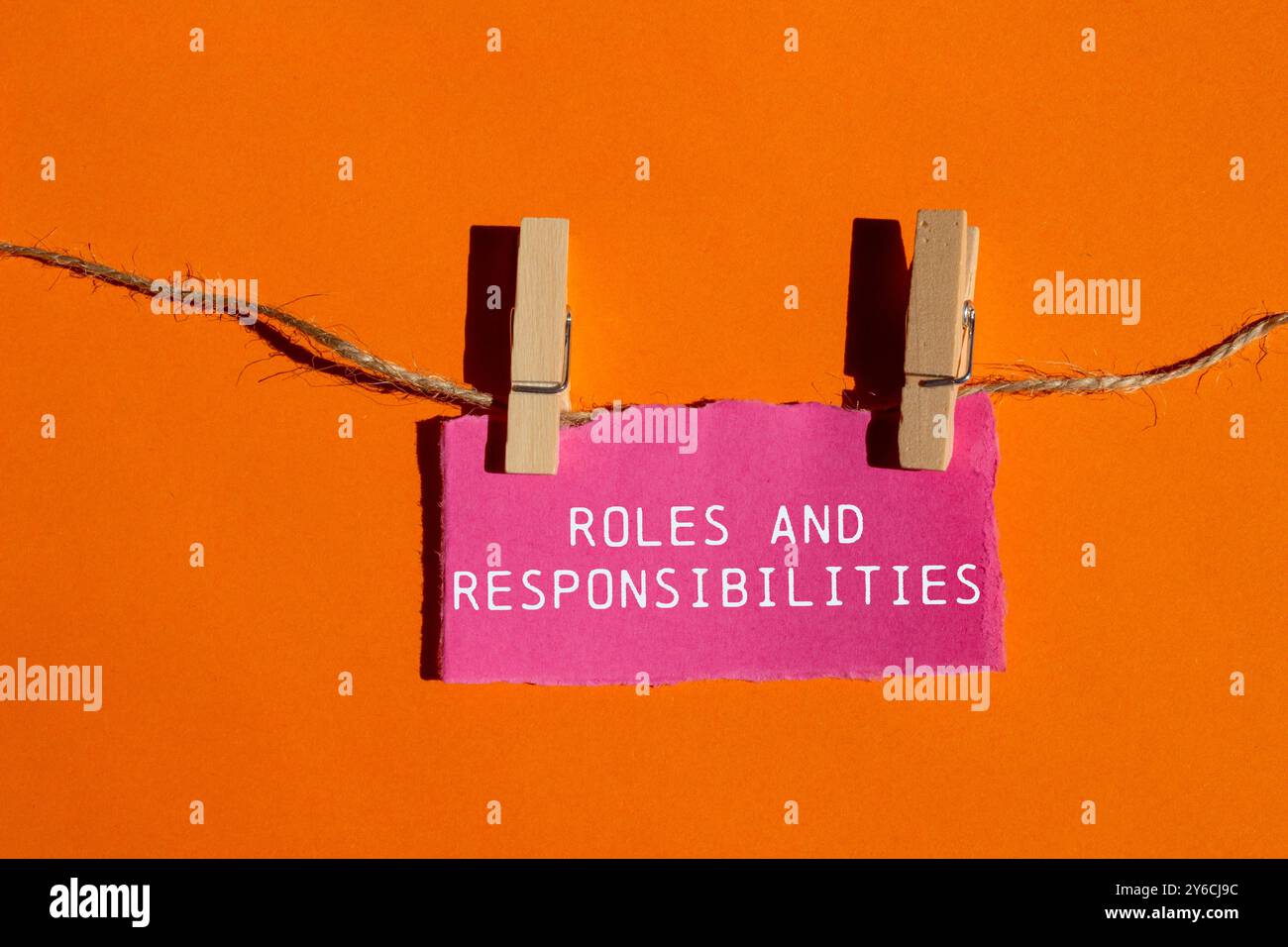 Roles and responsibilities message written on ripped pink torn paper ...