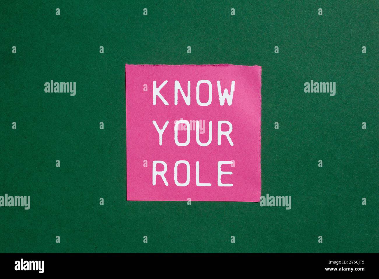 Know your role message written on ripped torn pink paper on green ...