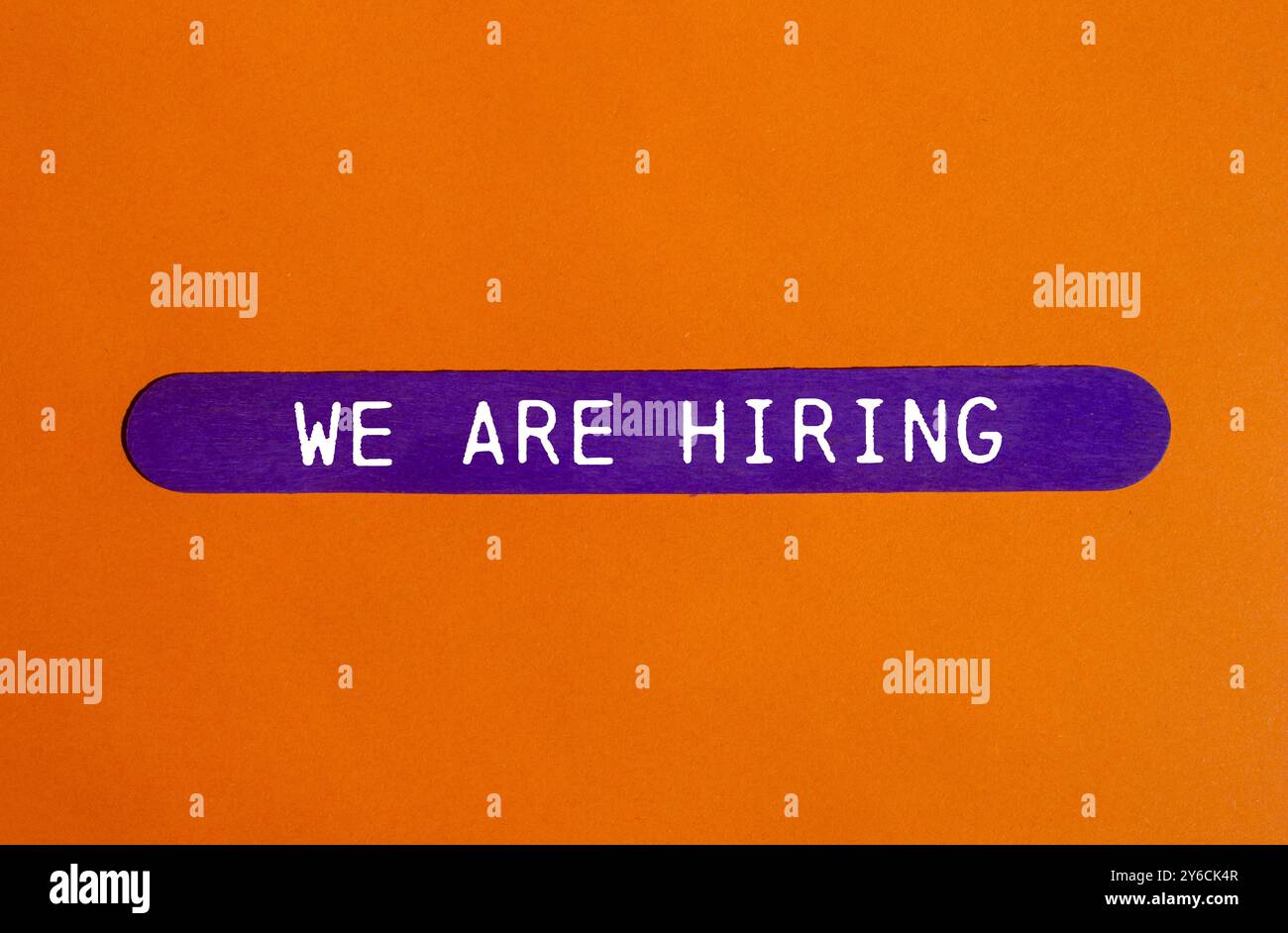 We are hiring message written on purple wooden stick on orange ...
