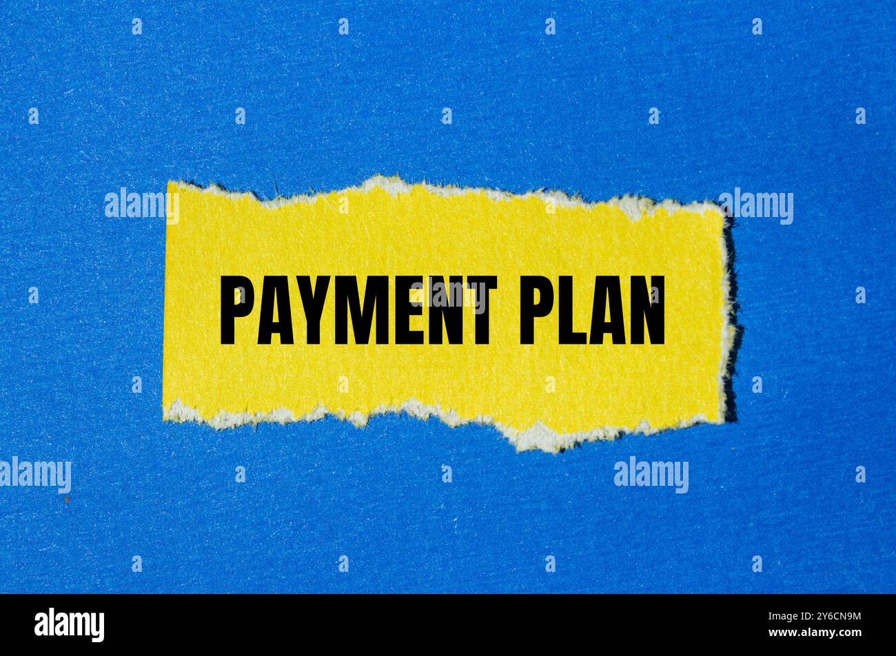 Payment plan message written on ripped yellow torn paper piece with blue background. Conceptual ...