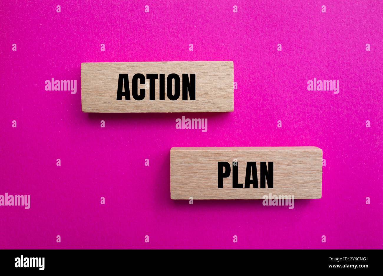 Action plan message written on wooden blocks with pink background ...