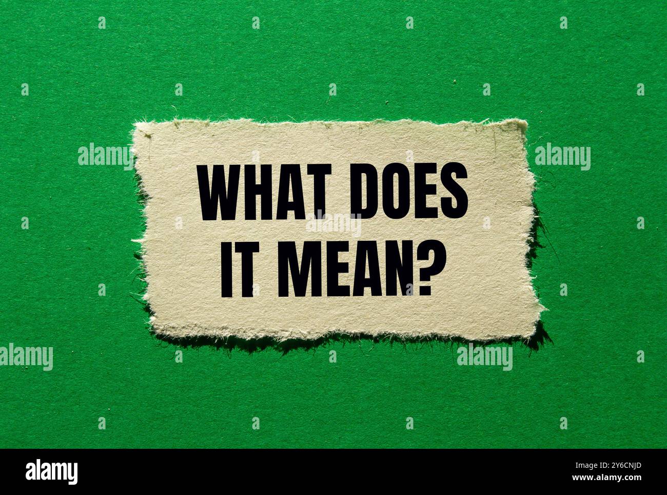 What does it mean question written on ripped torn paper piece on green ...