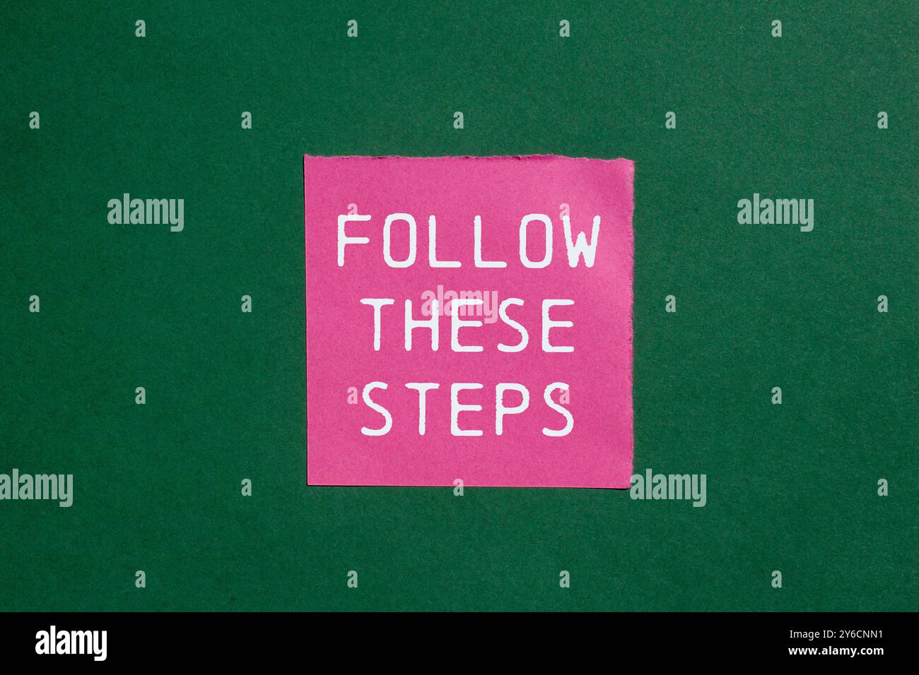 Follow these steps message written on ripped torn pink paper on green ...