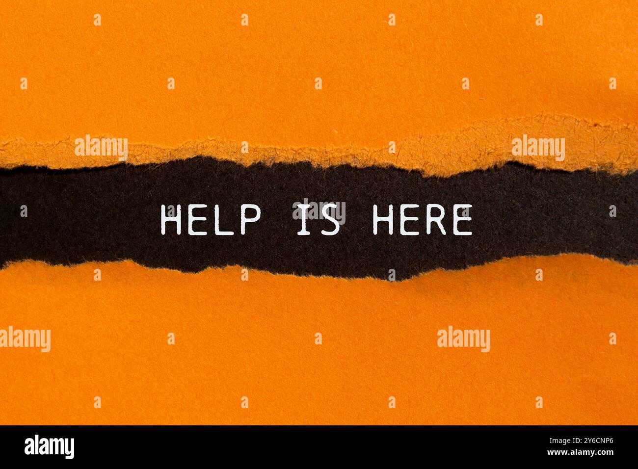 Help is here message written on ripped torn orange paper on black ...
