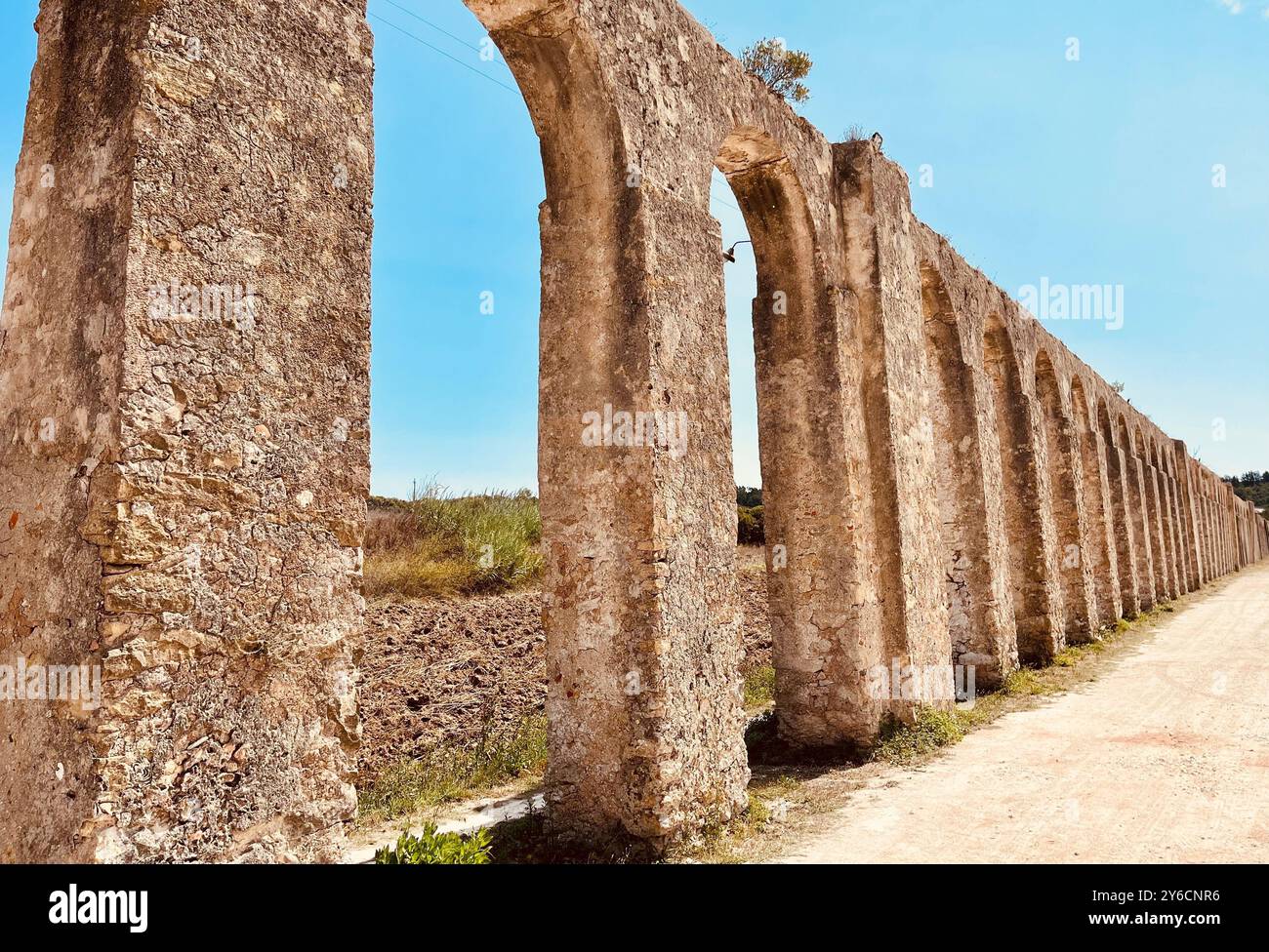 Ancient stone aqueduct under a clear blue sky, highlighting historical ...
