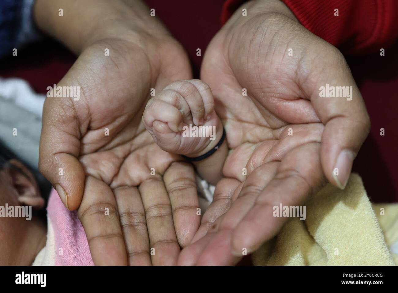 newborn hand welcome with other family members hand at home from ...