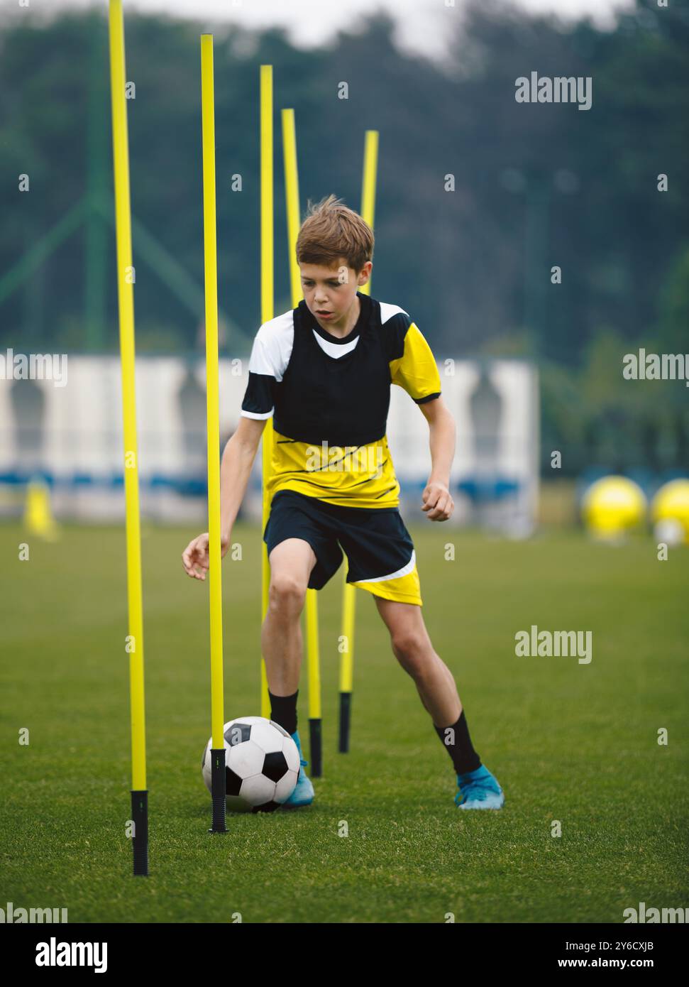 Soccer Players Running With Balls in Between Training Poles. Football ...
