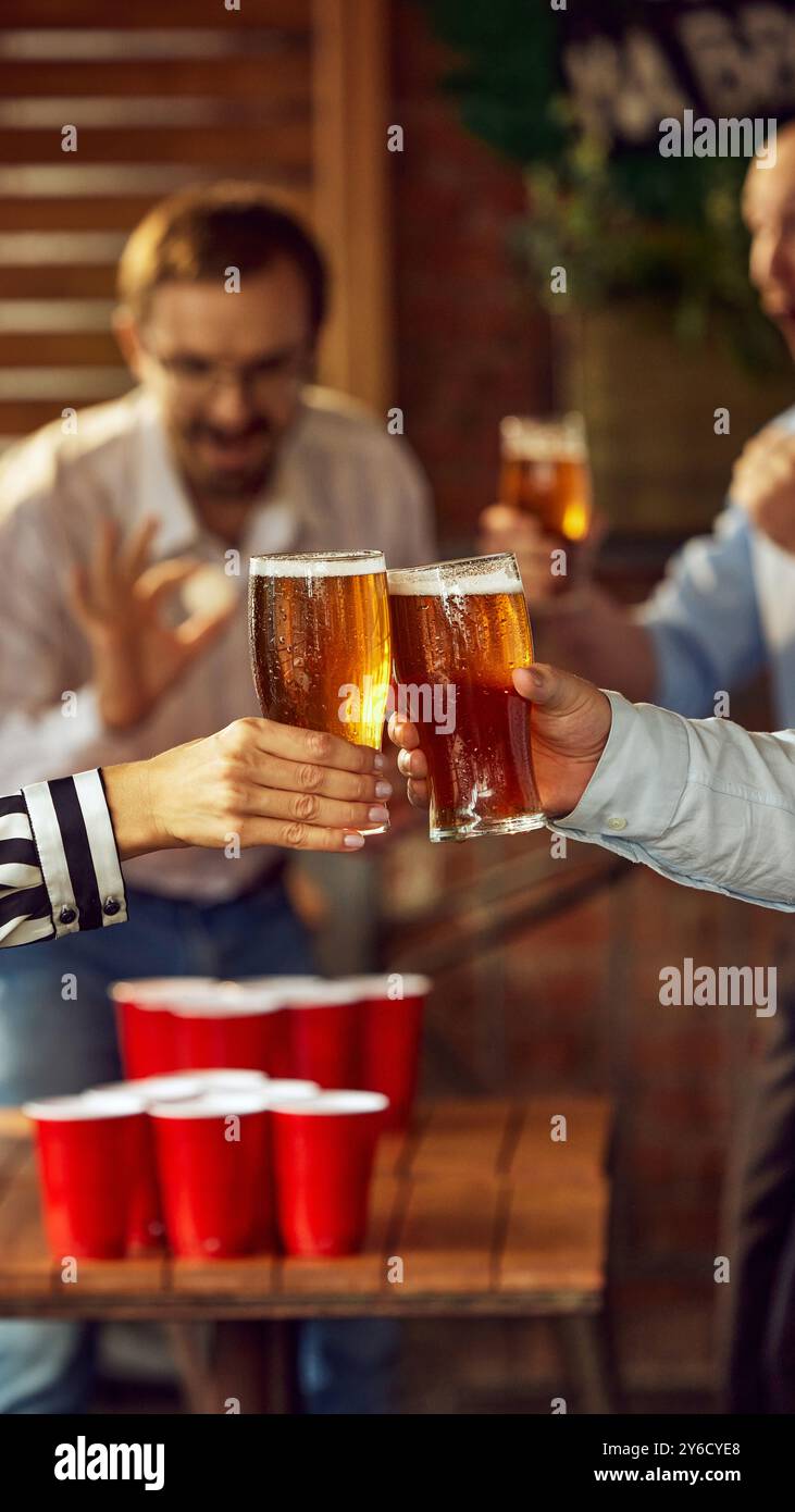 Focused on toast, while blurred figures behind cheer and engage ...