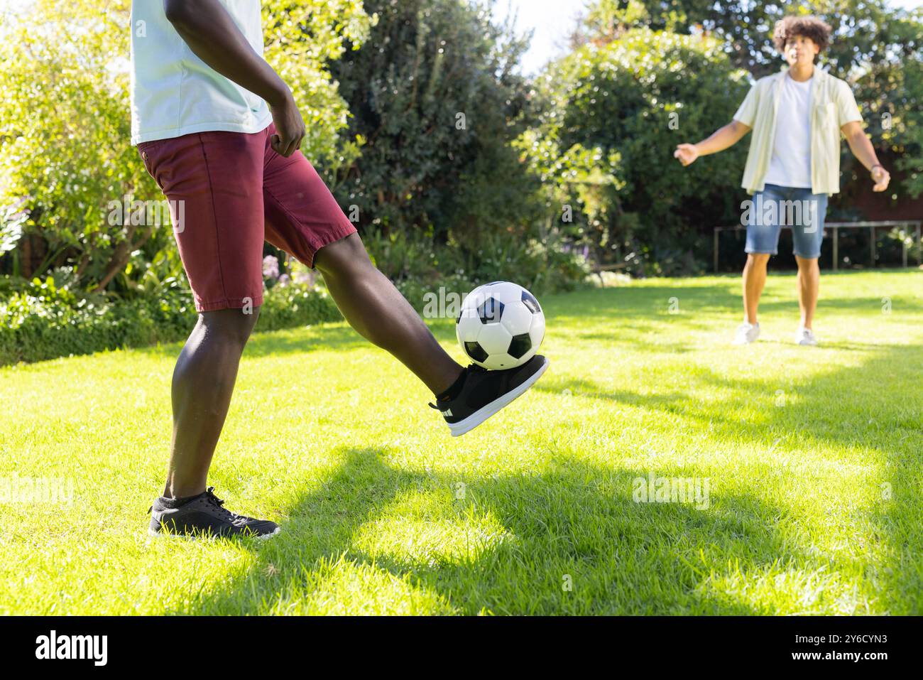 Playing soccer in backyard, two diverse male friends enjoying outdoor ...