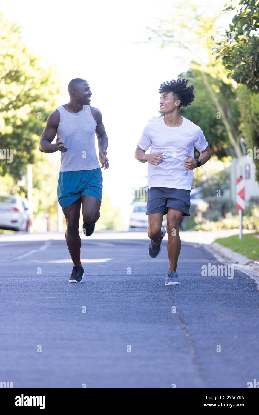 Running together on street, two diverse male friends enjoying outdoor workout and bonding Stock ...