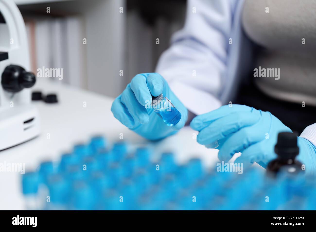 Scientist in Laboratory Handling Blue Liquid Samples with Microscope ...
