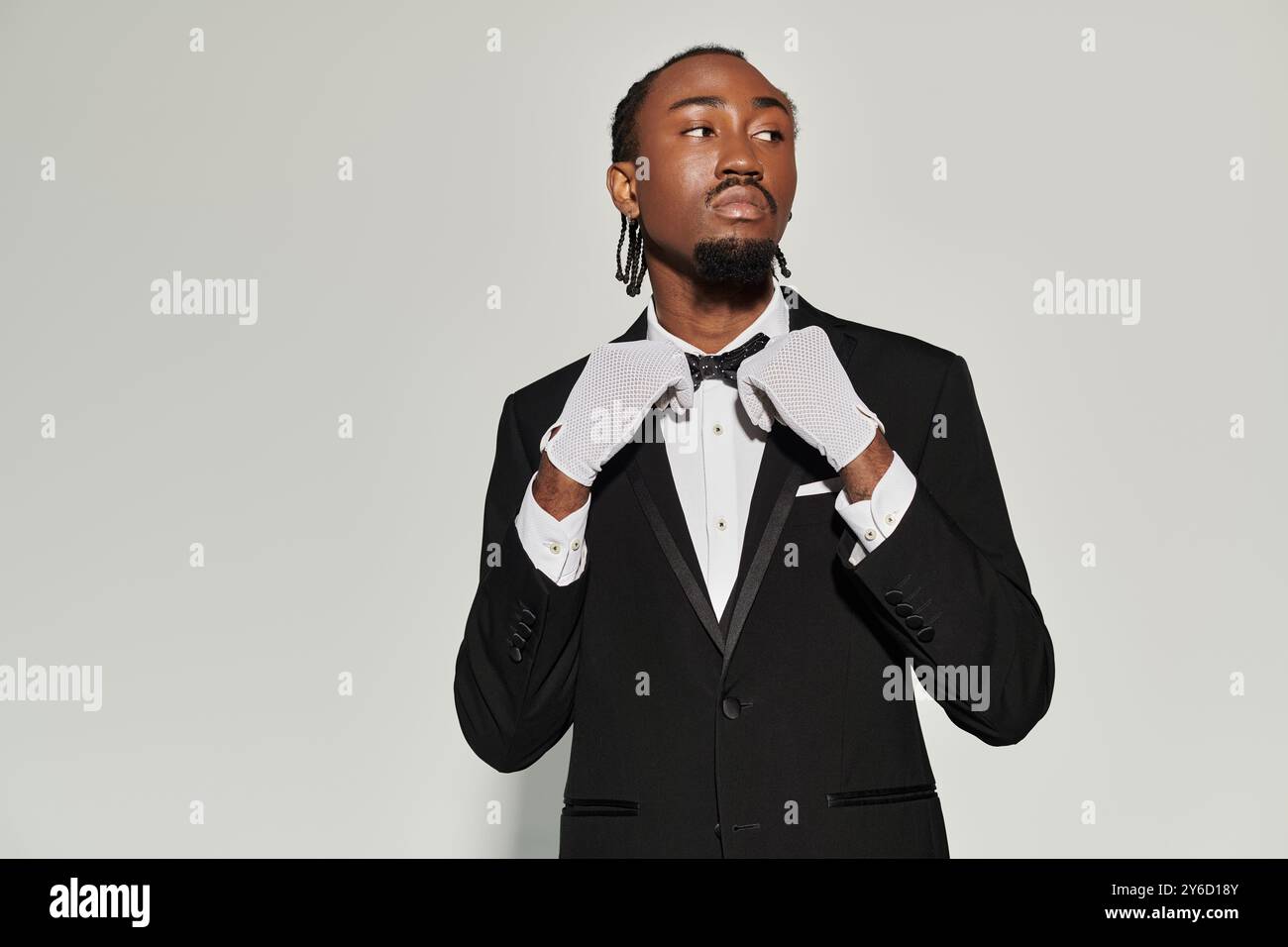 A young African American man in a sharp suit and vest exudes confidence ...
