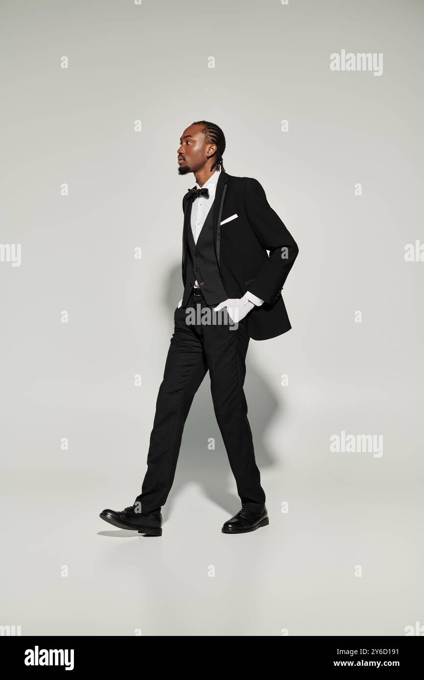 A stylish young man dressed in a tailored suit and vest walks with ...