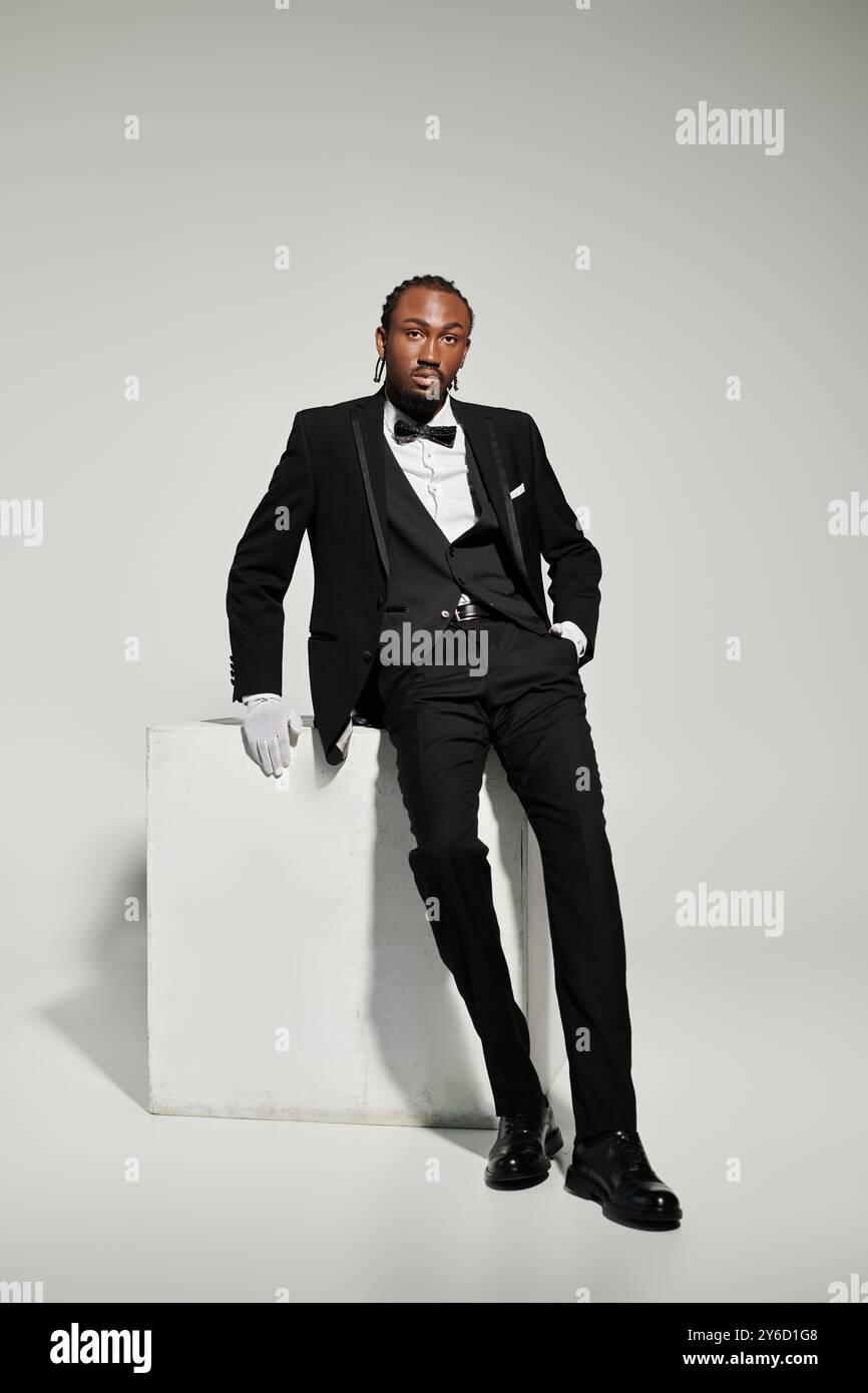 A confident young man in a tailored suit and vest stands elegantly on a ...