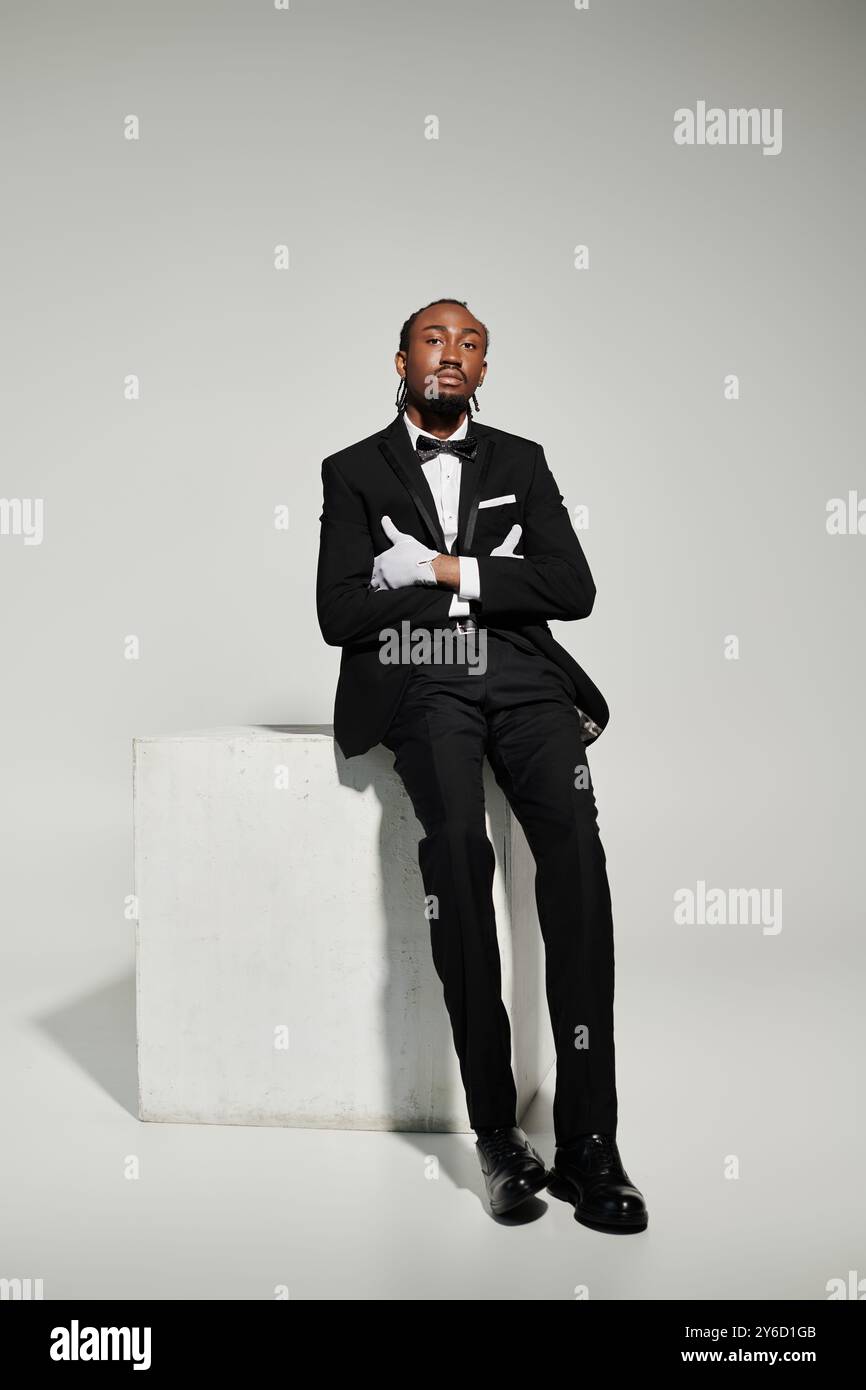 A young man dressed in a sharp suit and vest exudes elegance as he ...