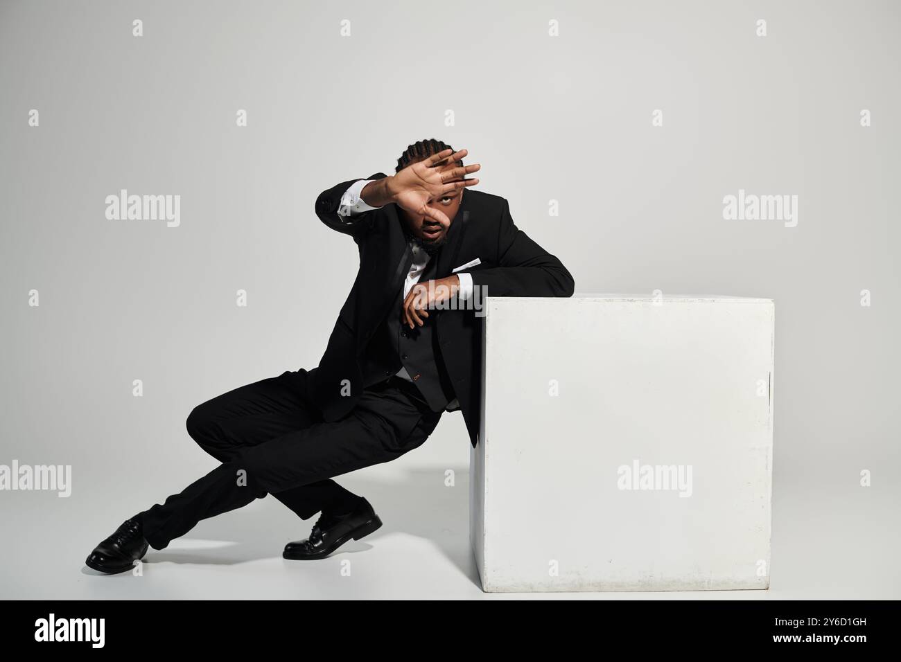 A young African American man in a sharp suit and vest strikes a dynamic ...