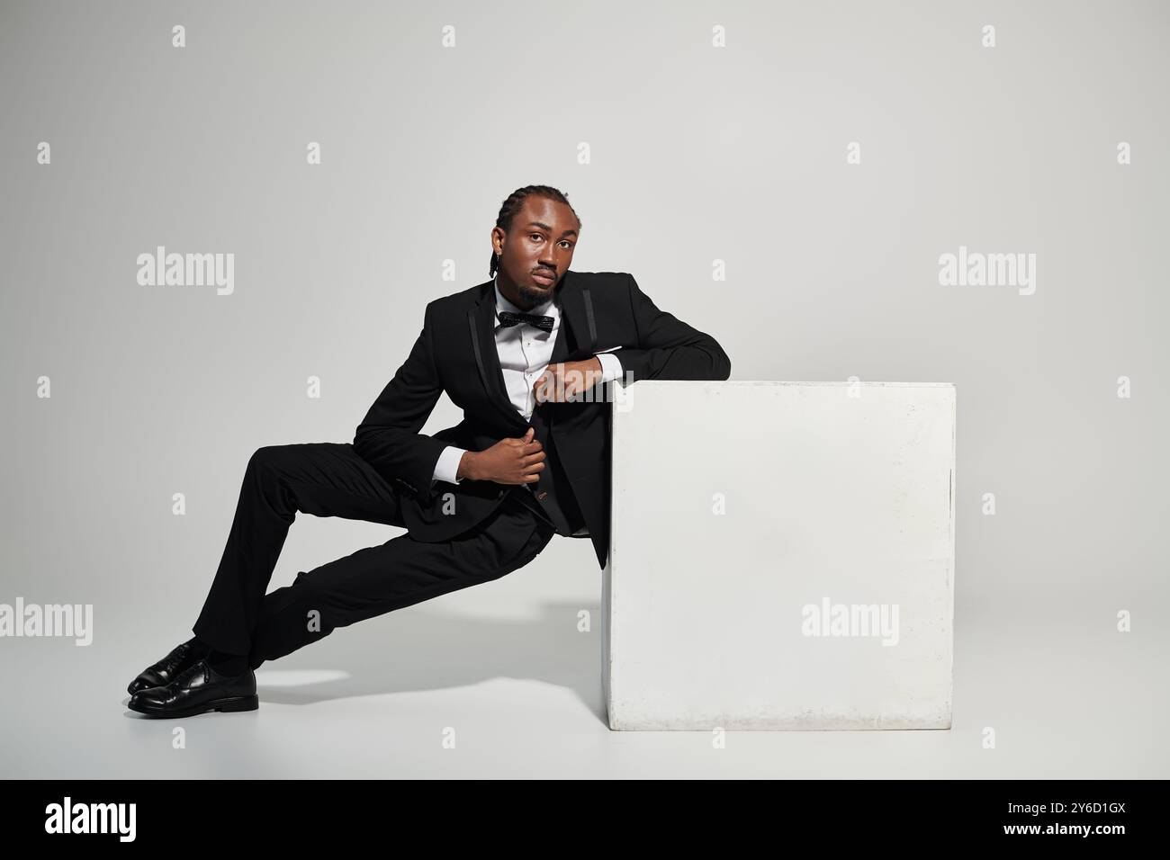 Dressed in a tailored suit, a young man showcases his style and ...