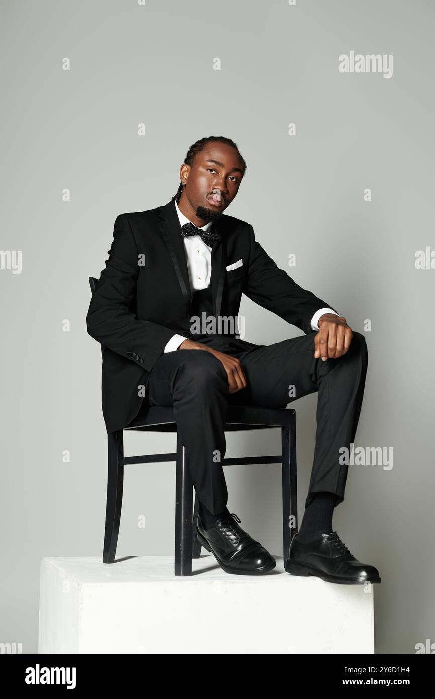 Dressed elegantly in a suit and vest, a young man strikes a poised pose ...
