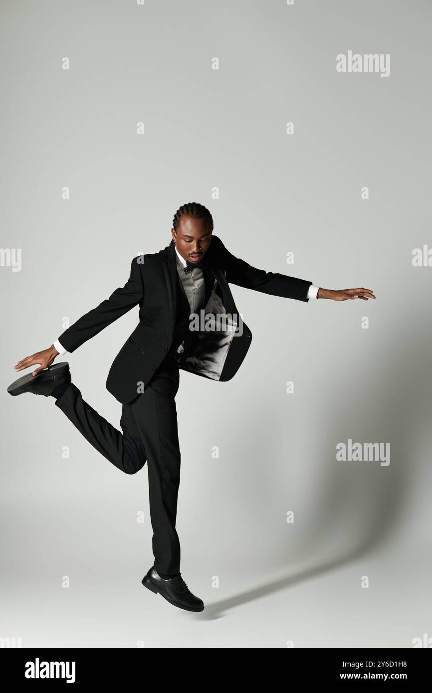 A confident young man in a tailored suit strikes a dynamic pose against ...