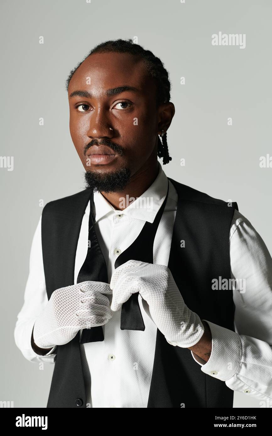 A young African American man in a stylish suit stands confidently ...