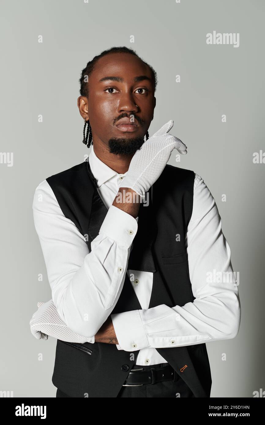A young African American man, dressed in a formal suit and vest, poses ...