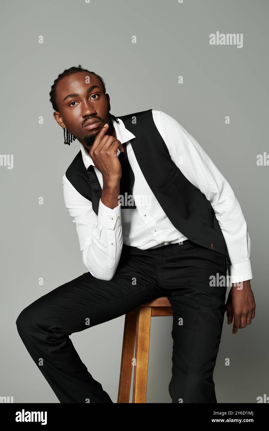 A confident young Black man in a sleek suit poses against a neutral ...