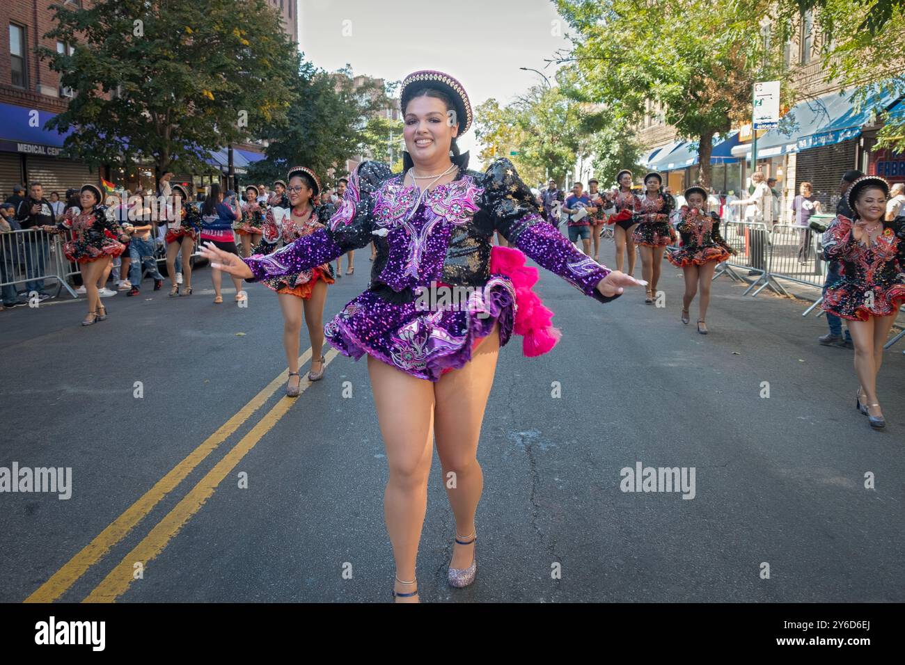 A happy Bolivian American woman marches & dances in a colorful costume ...
