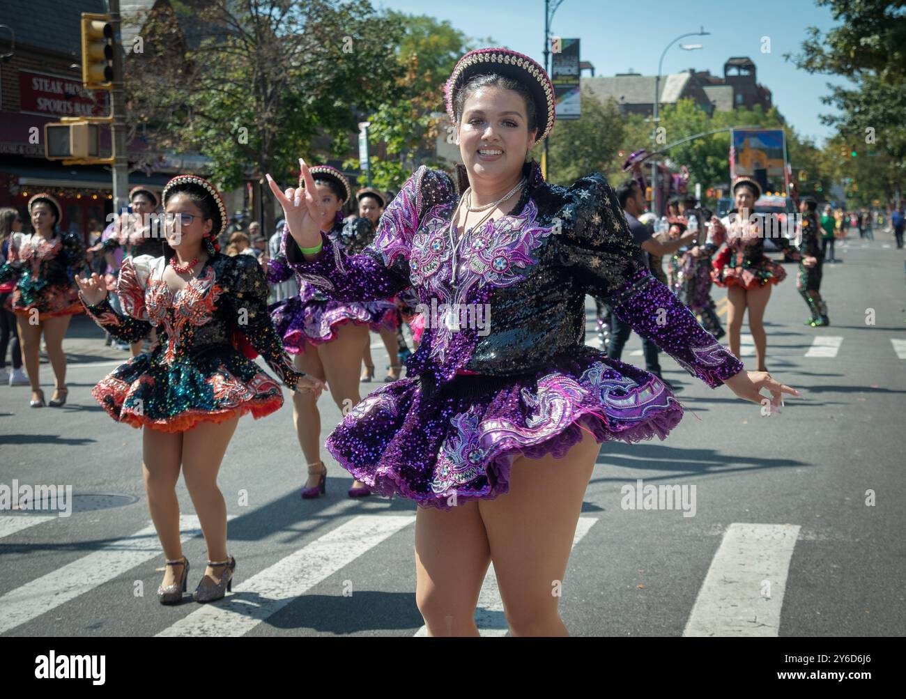A happy Bolivian American woman marches & dances in a colorful costume ...