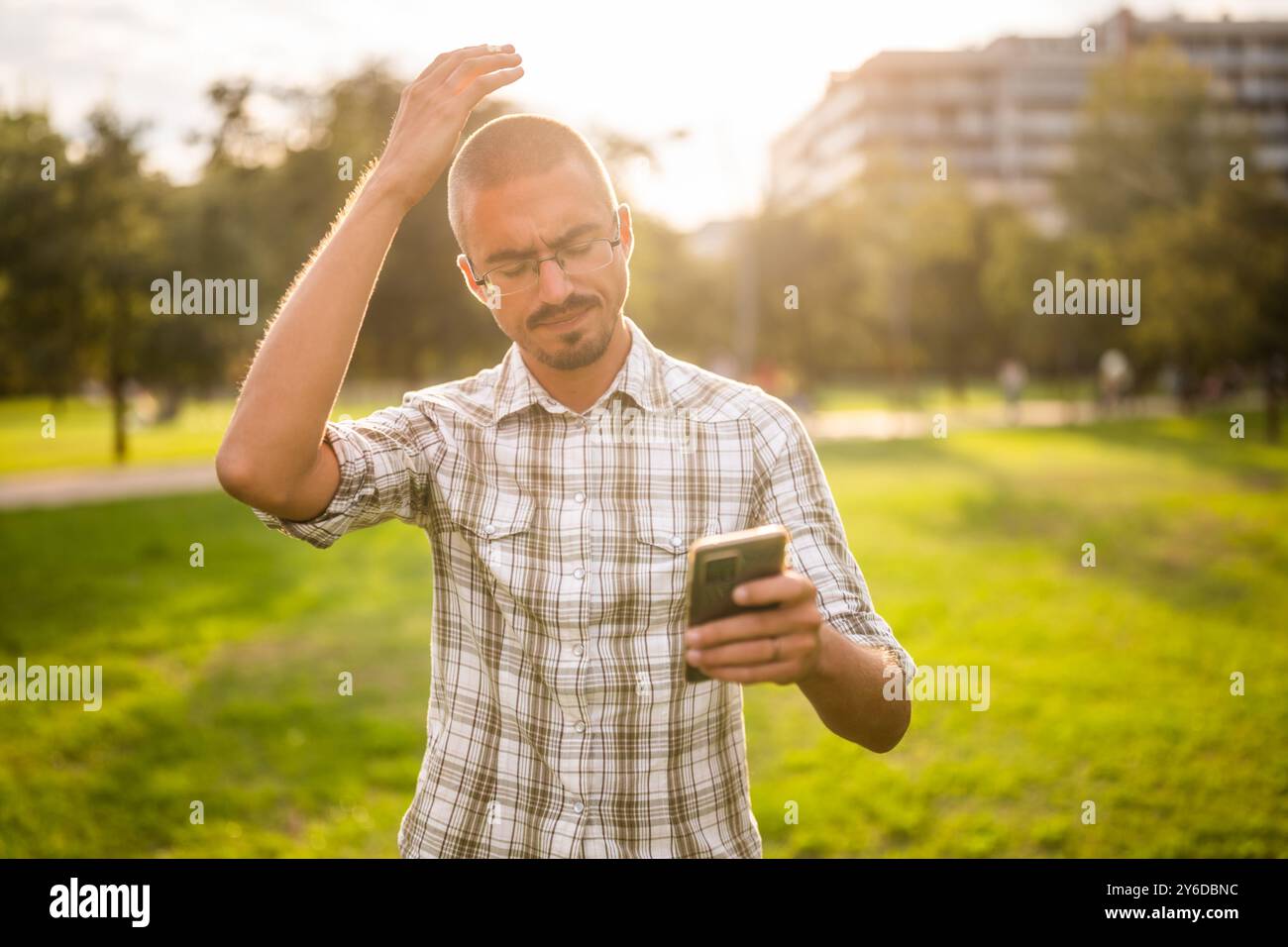 Portrait of angry adult man in park who is using smartphone Stock Photo ...