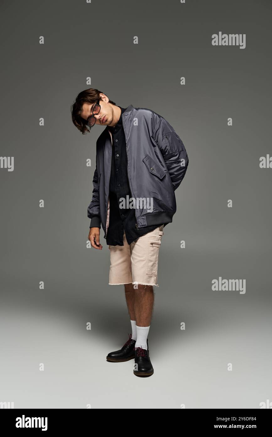 A young man showcases his fashionable autumn outfit, expressing ...