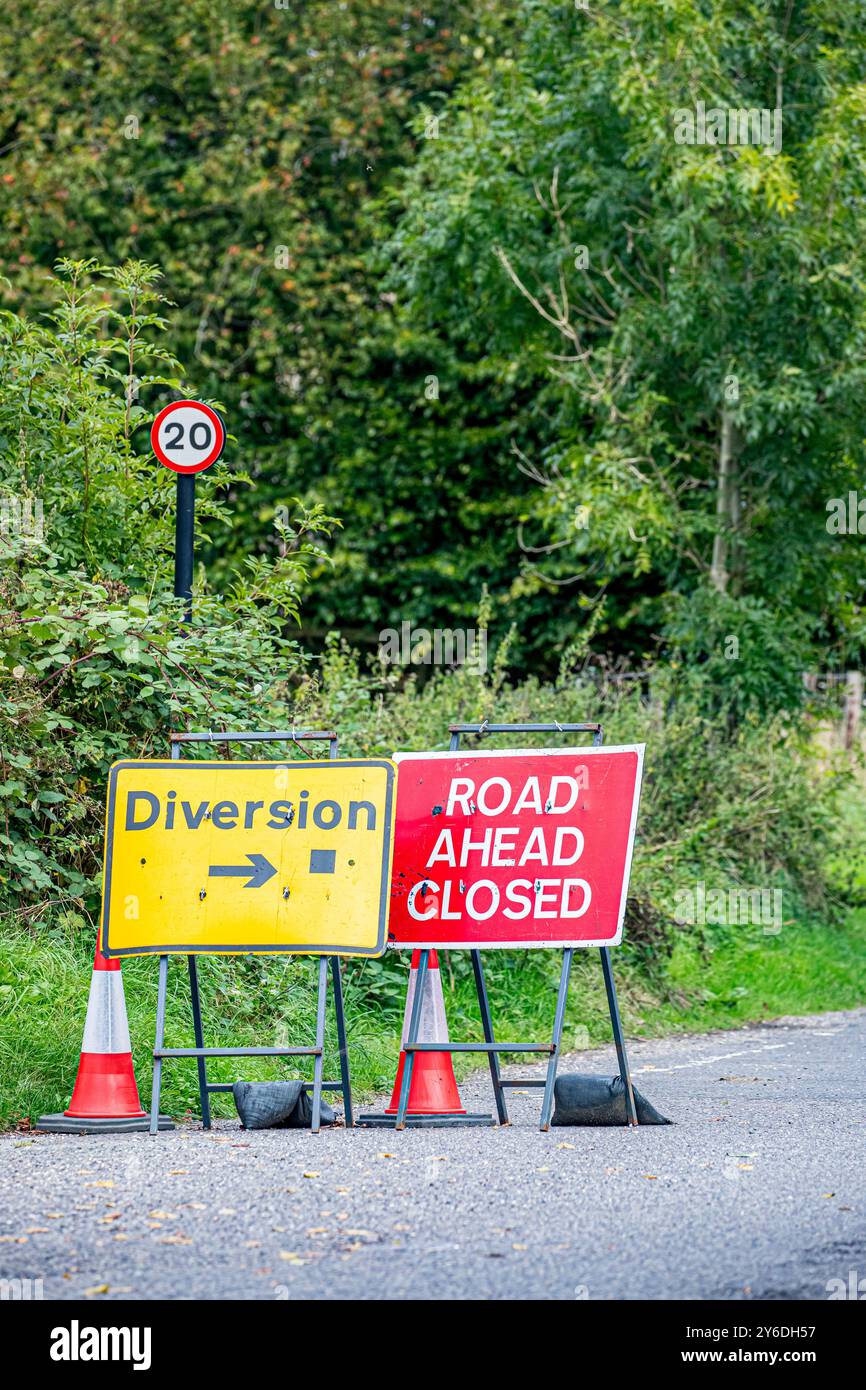 Road Closed Ahead sign, a yellow directional Diversion sign and two ...