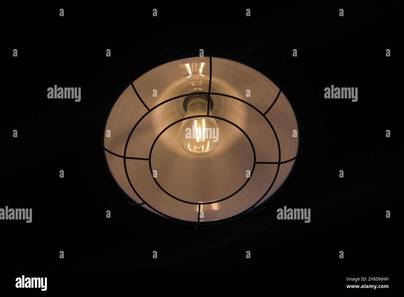 Image of a utilitarian overhead lamp emitting the warm glow of ...