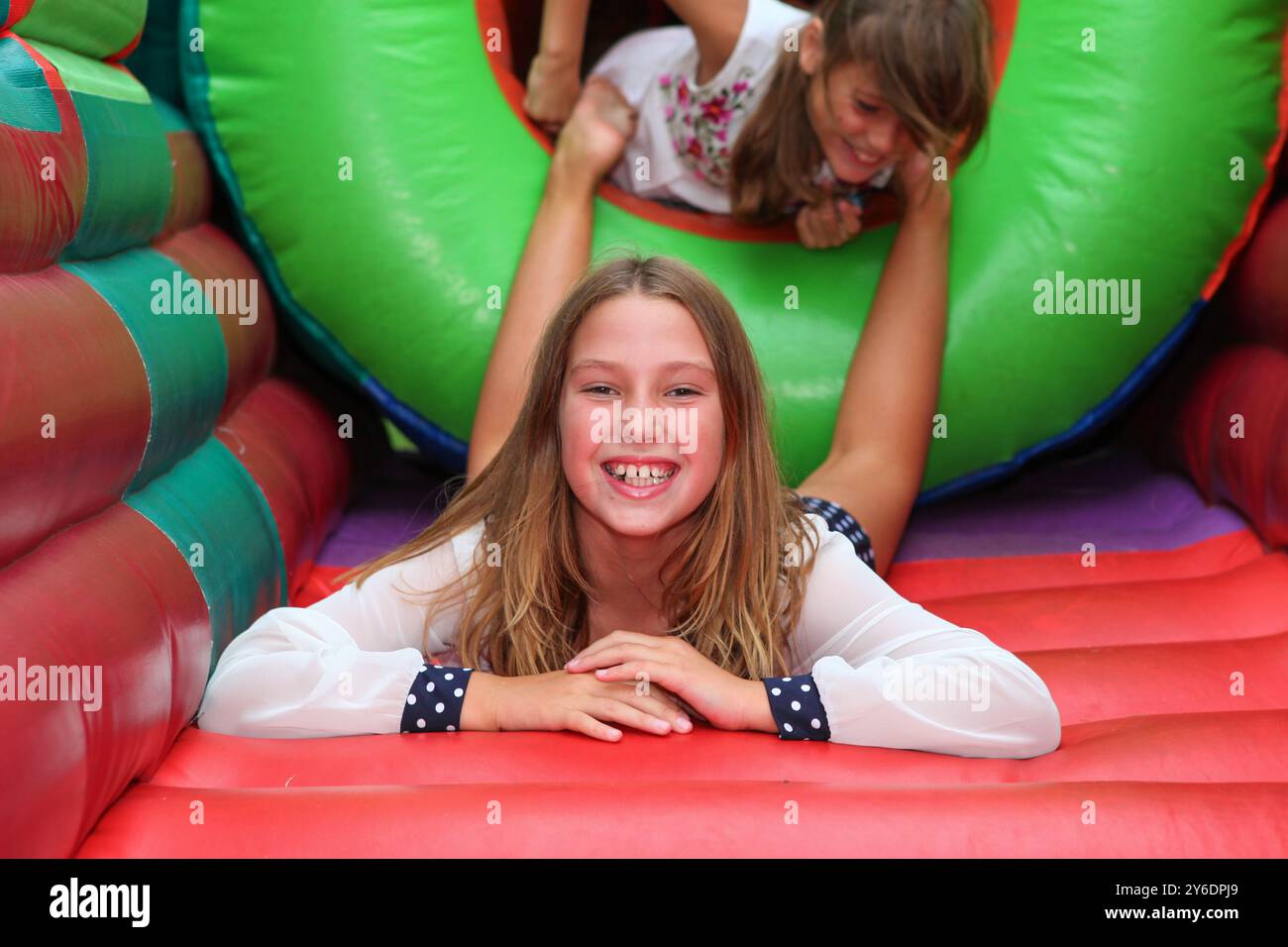 Cute girl in a colorful inflatable bounce house. having fun at a ...