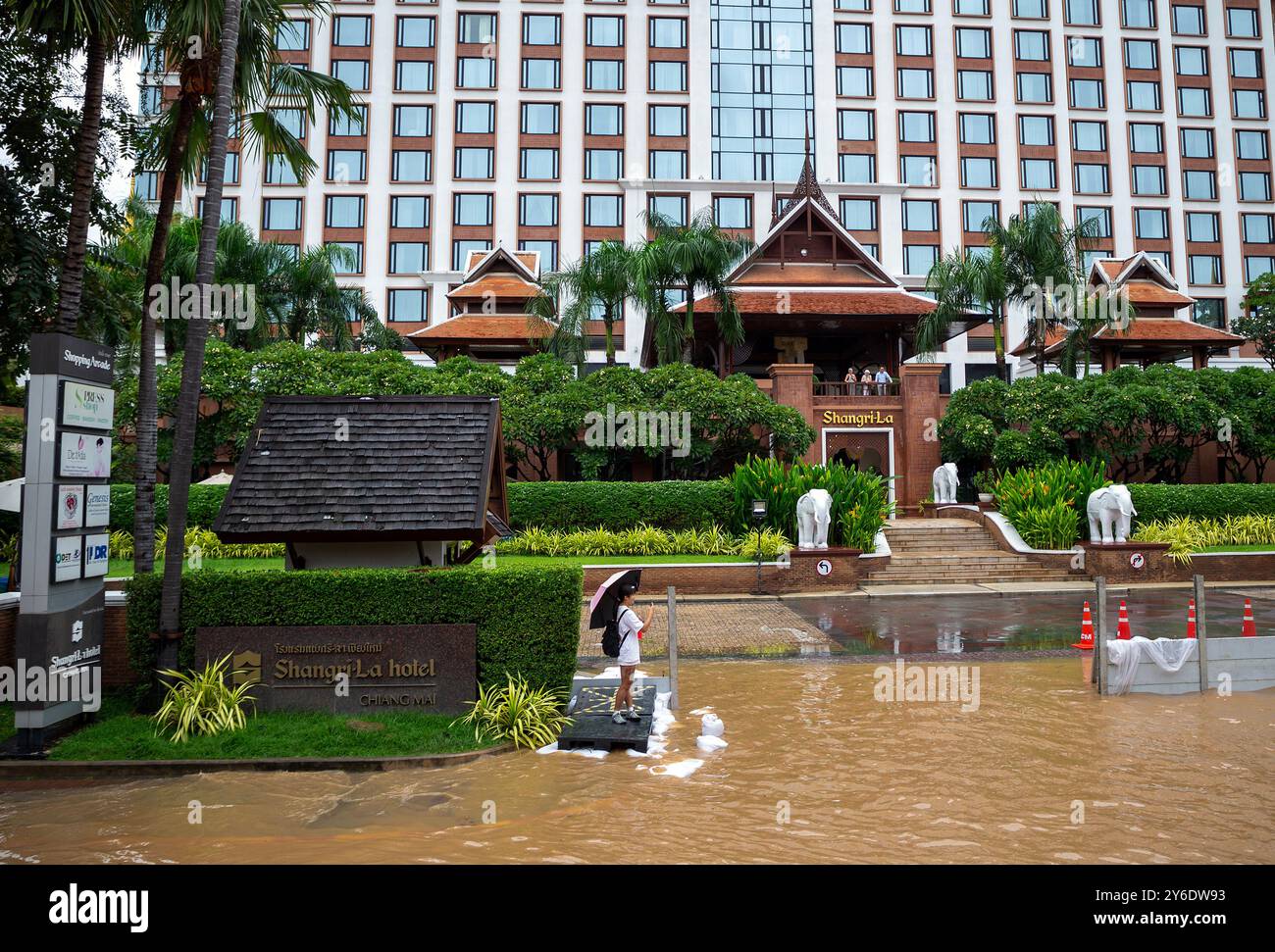 A woman takes photos of a flooded street in the Chang Khlan area due to ...
