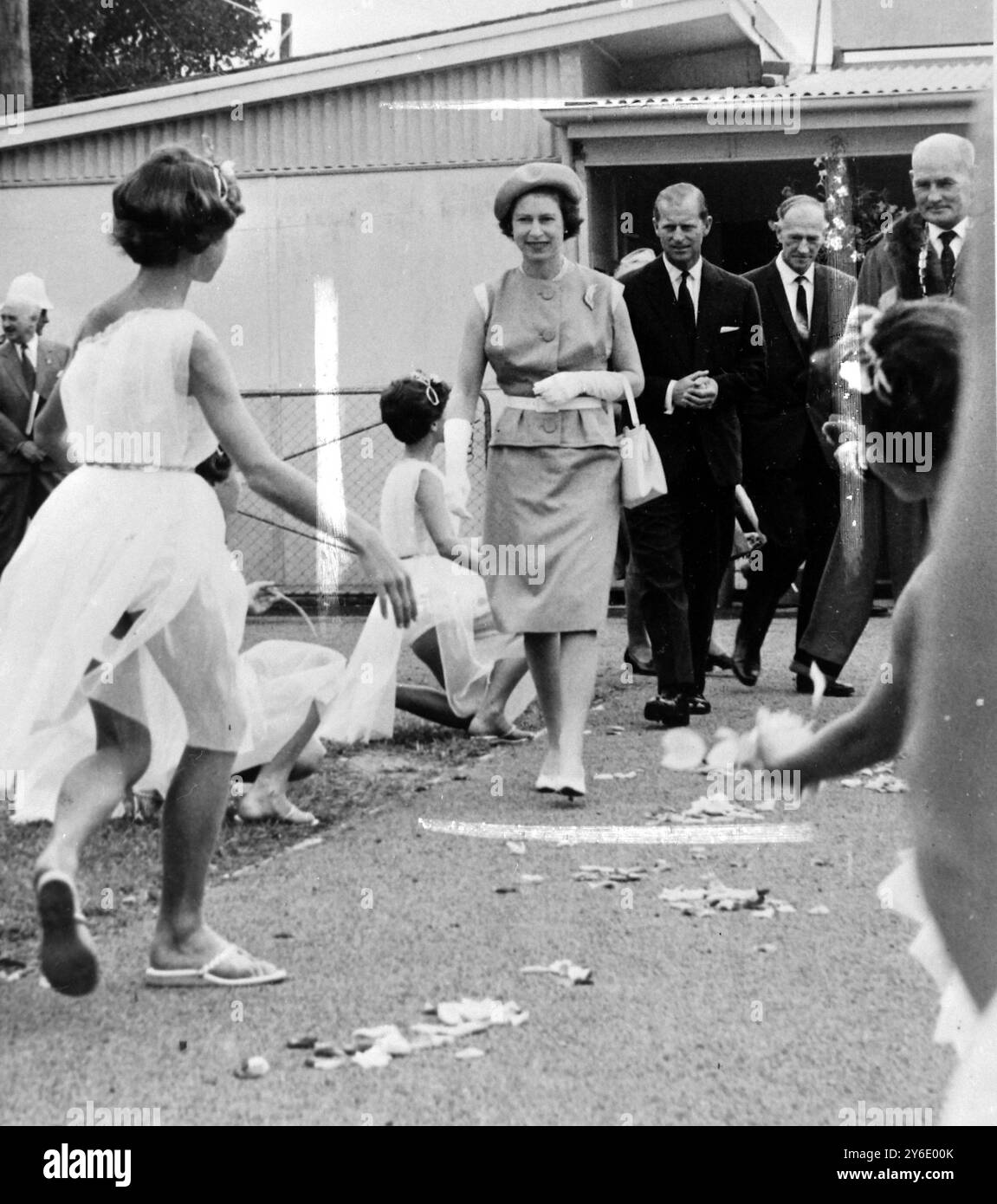 QUEEN ELIZABETH II AND PRINCE PHILIP WALK AND CHILDREN THROWING PETALS ...