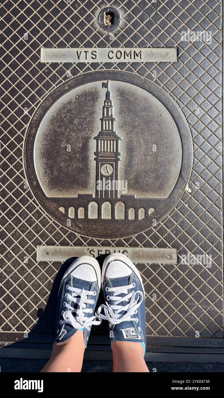 Feet in converse shoes with an iron manhole cover featuring the Ferry ...