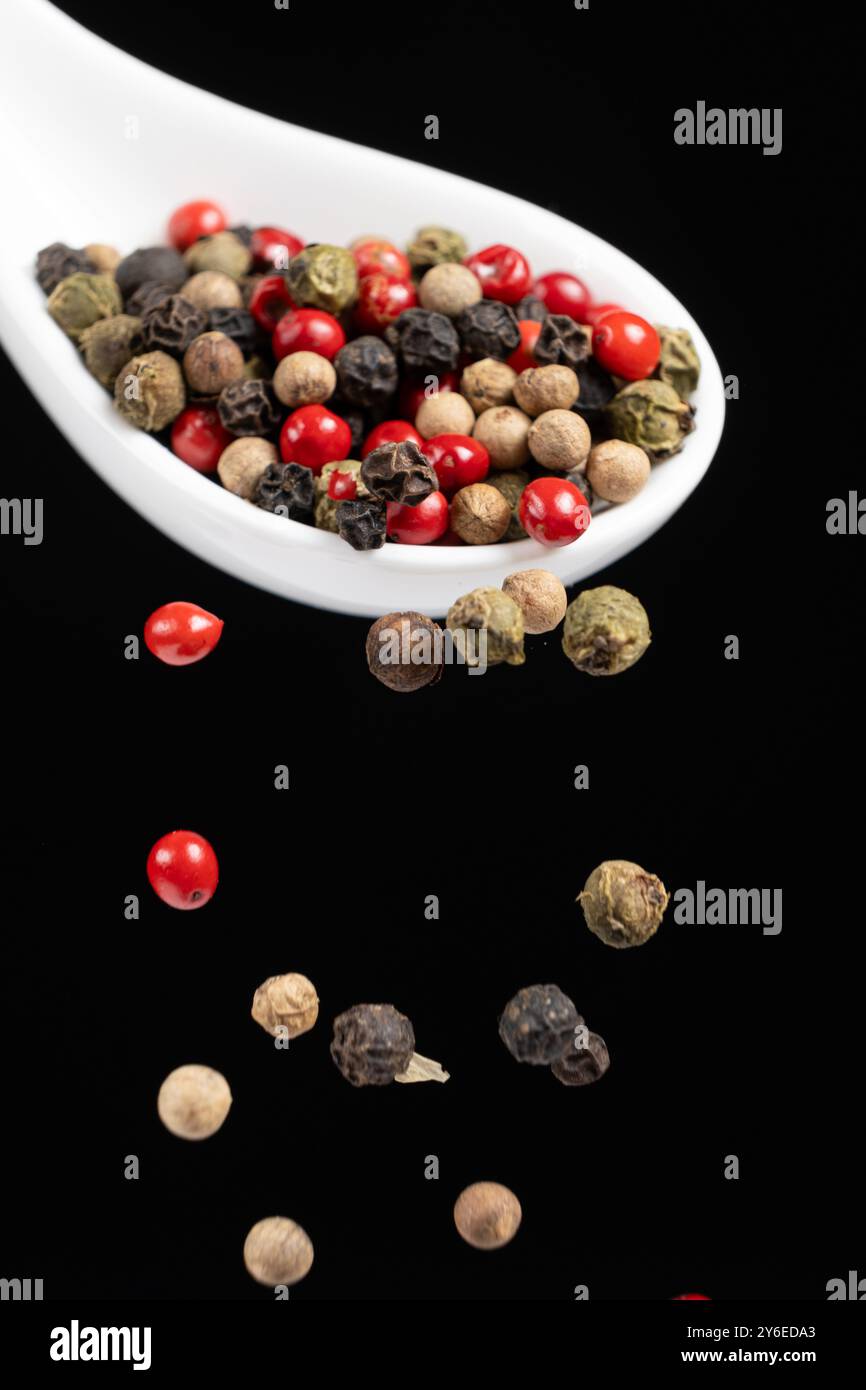 Different types of peppercorns pouring. Red, green, white and black ...