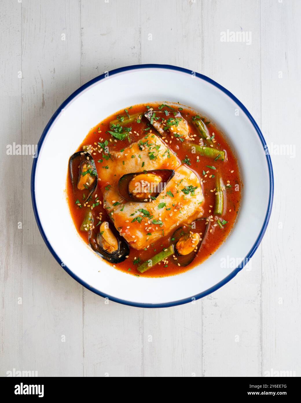 Hake cooked with tomato and mussels. Top view table with decoration ...