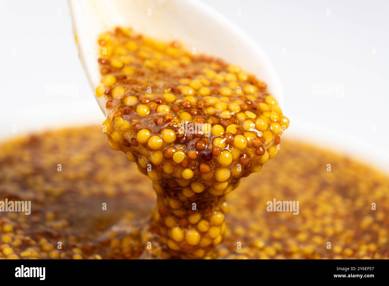 Traditional French Dijon mustard in a spoon on a white background Stock ...