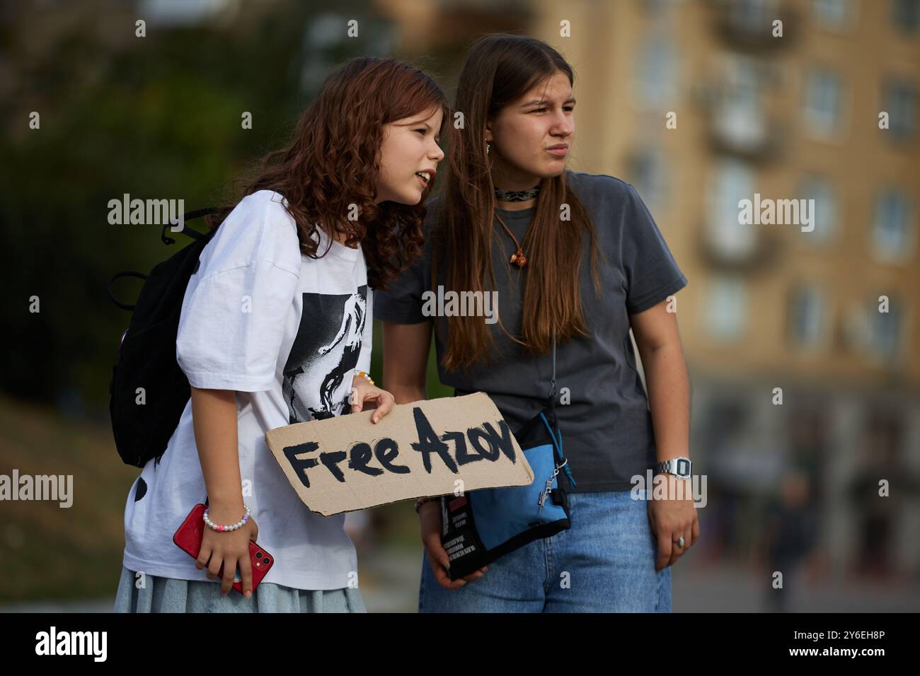 Young Ukrainian girl hold a sign Free Azov in hand on a public ...