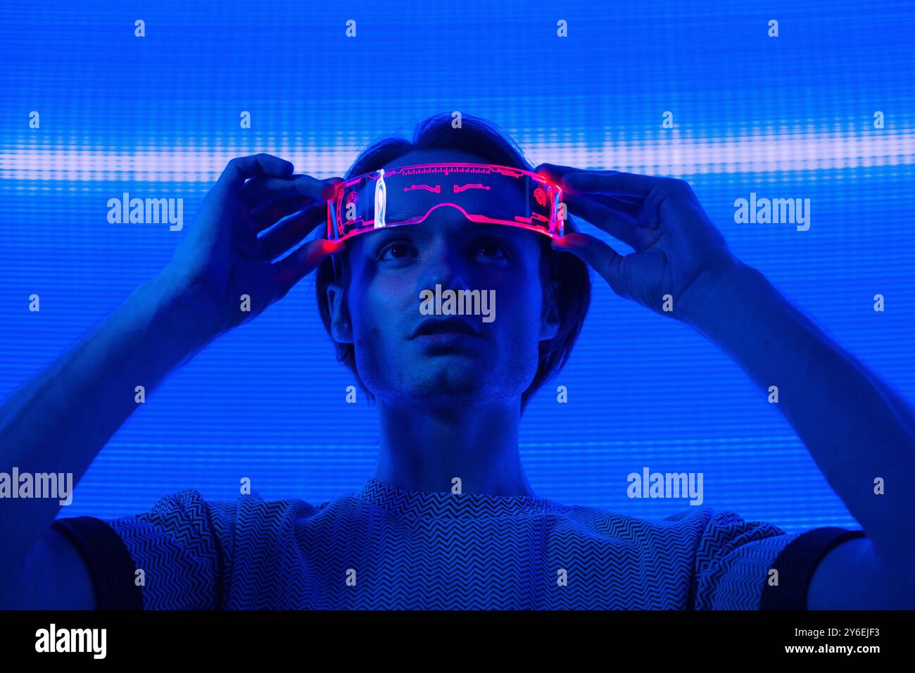 Creative futuristic man with smart neon glasses in a neon room a neon ...