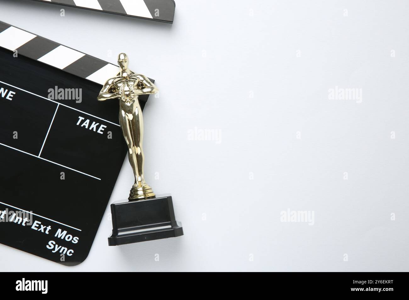 Golden Oscar award and movie clapper on white background, top view ...