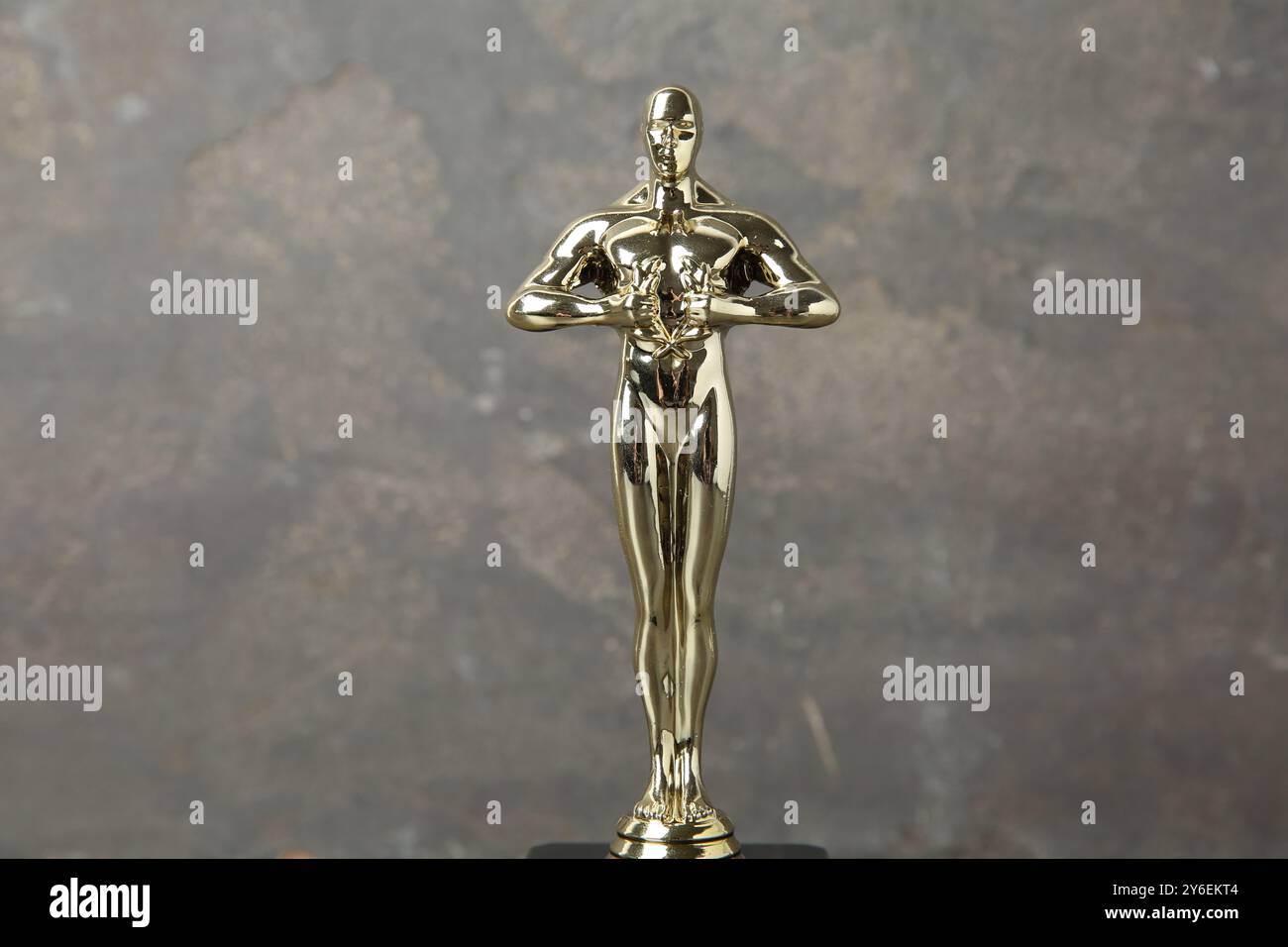 Golden Oscar award against blurred gray background Stock Photo - Alamy