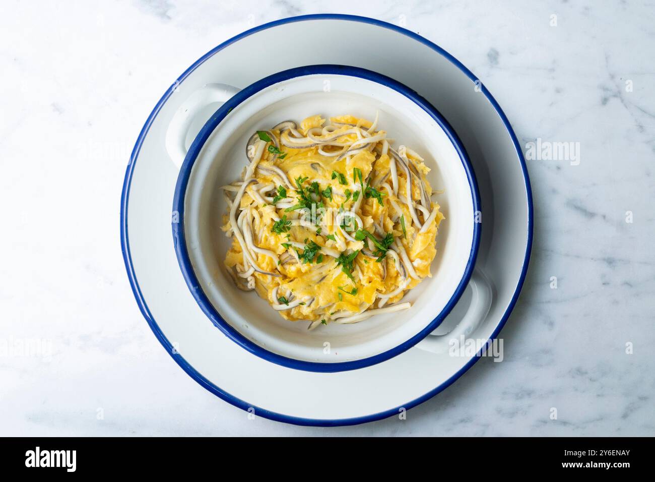 Scrambled eggs with baby eels and garlic. Top view table with ...
