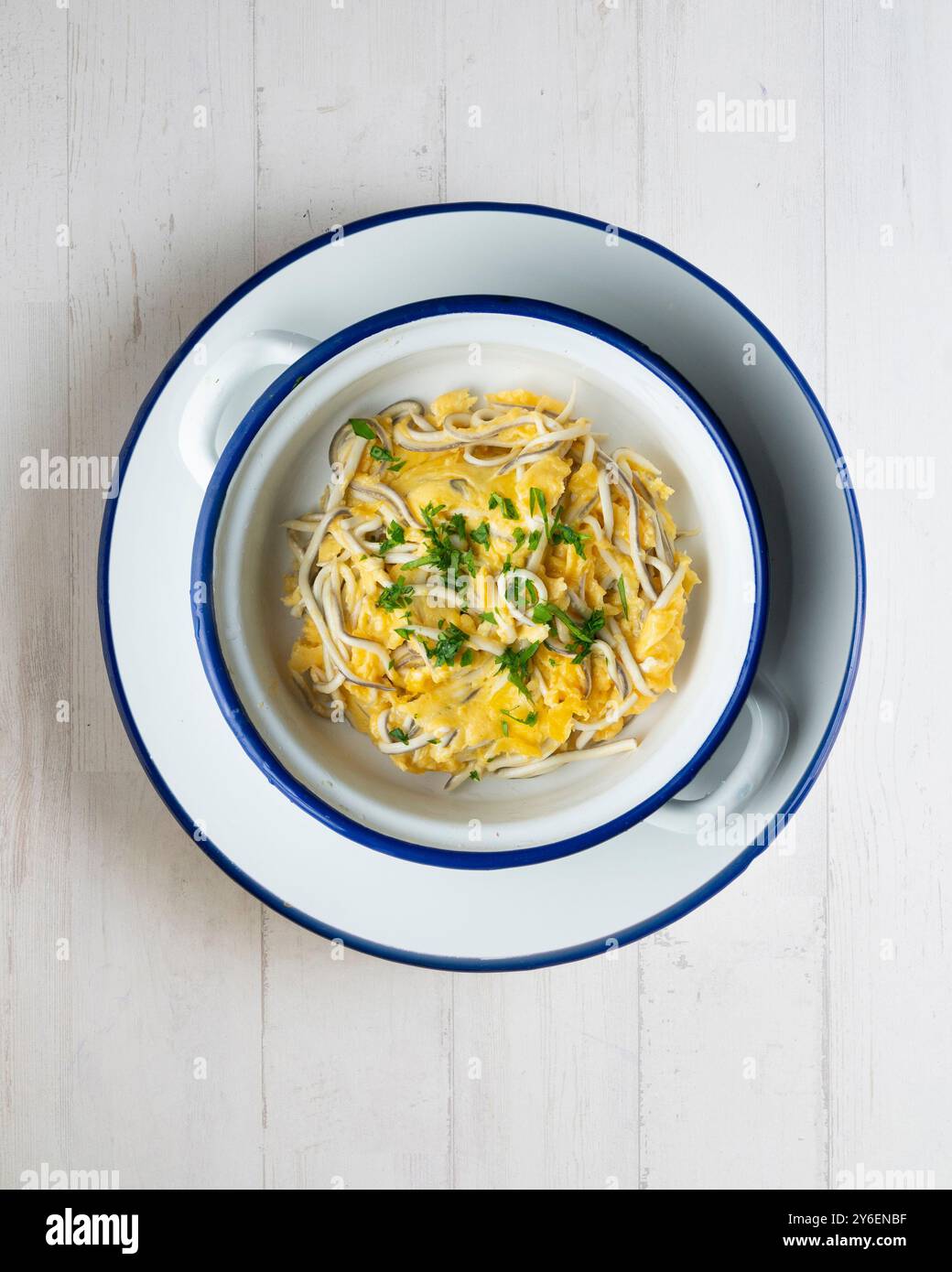 Scrambled eggs with baby eels and garlic. Top view table with ...