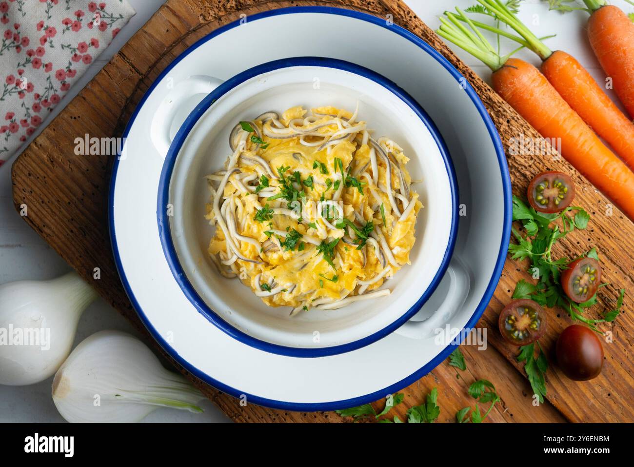Scrambled eggs with baby eels and garlic. Top view table with ...
