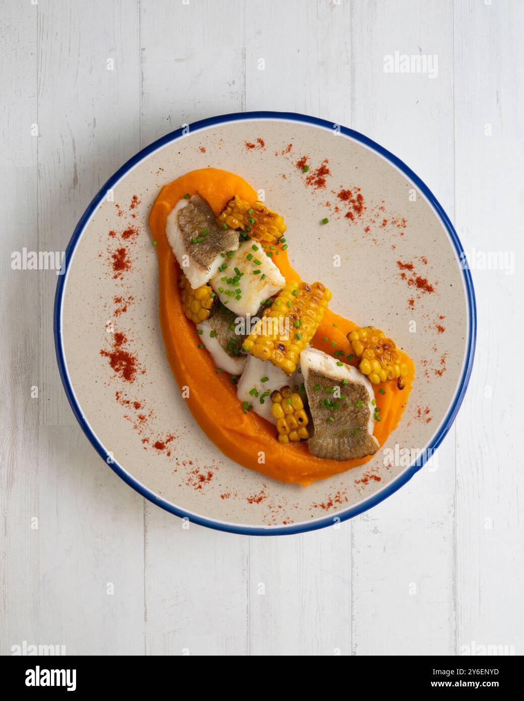 Delicious sole fish with carrot cream and corn. Top view table with ...