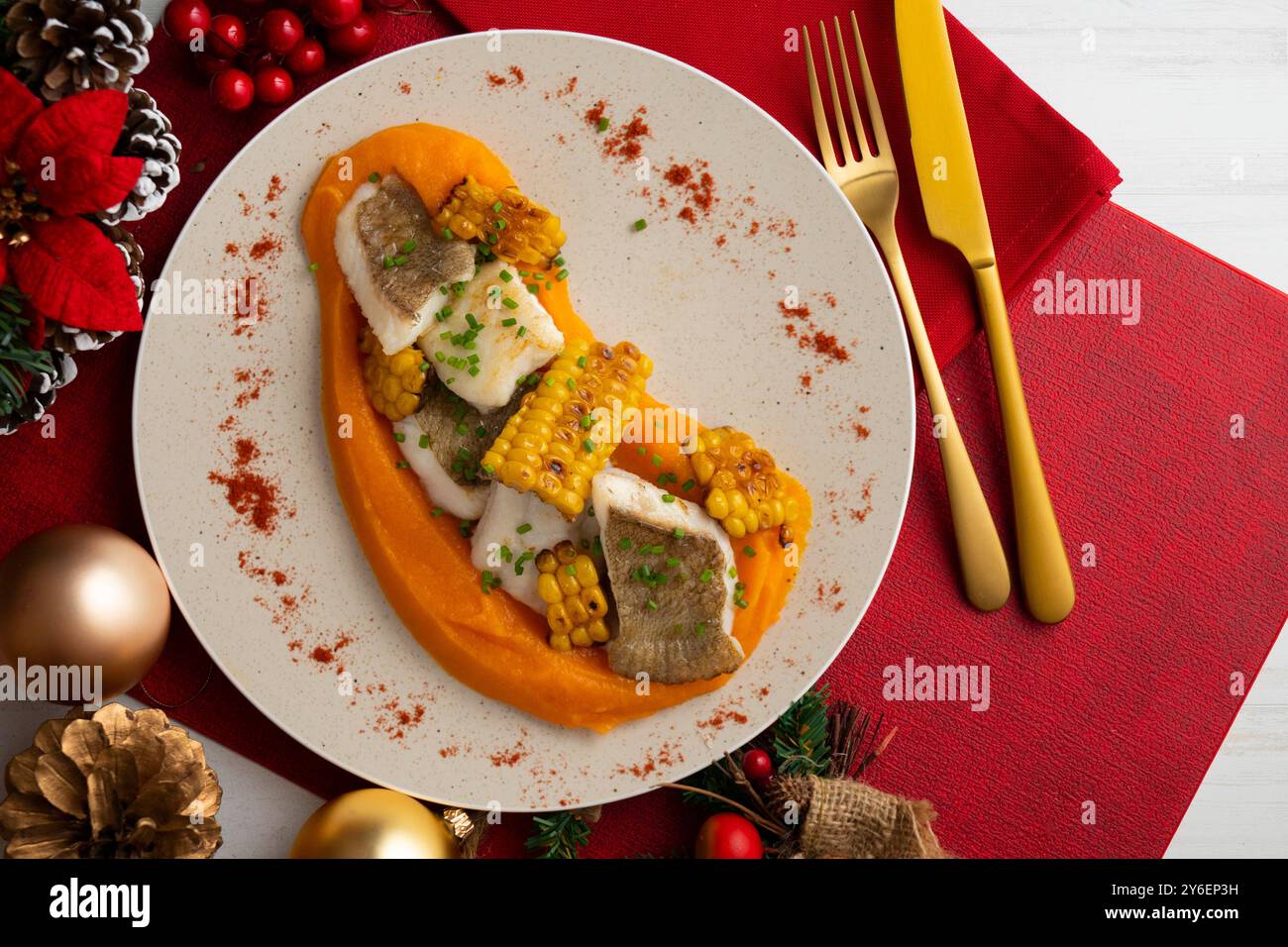Delicious sole fish with carrot cream and corn. Top view table with ...