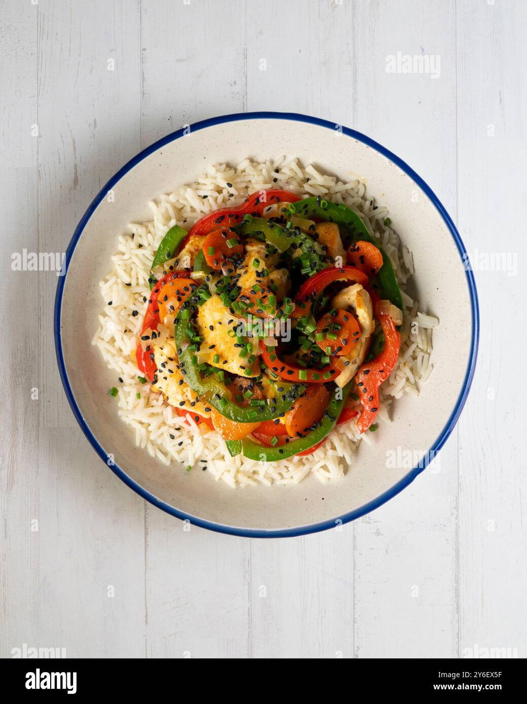 Wok of chicken strips with peppers and rice. Top view table with ...