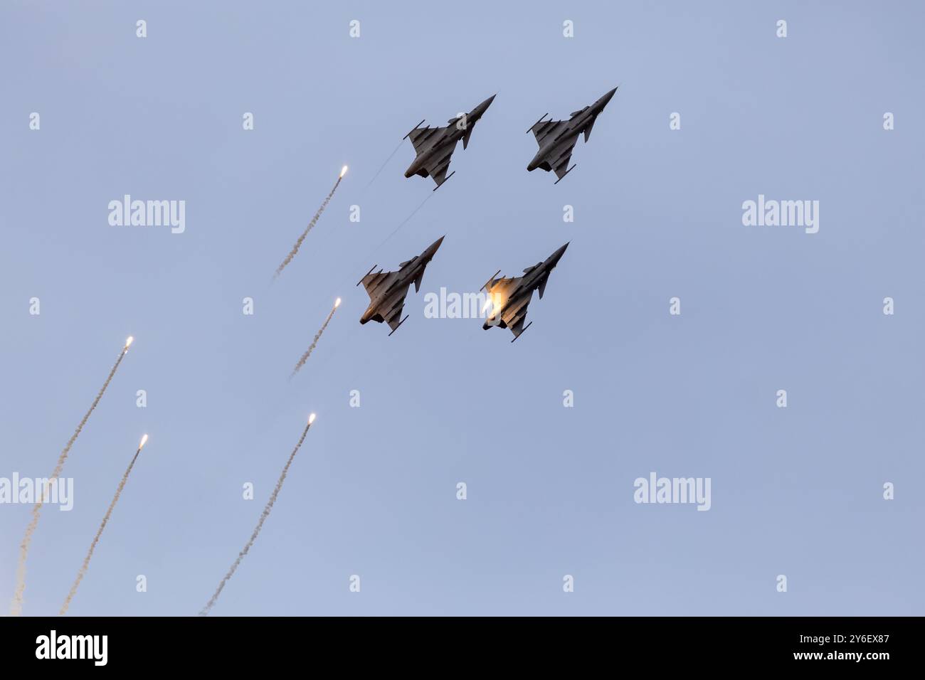 Four fighter jets performing an aerial display with flares against a ...